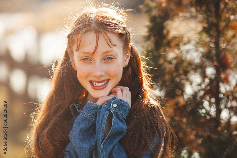 Pretty young red-haired girl outdoors. Teenager closeup portrait ...