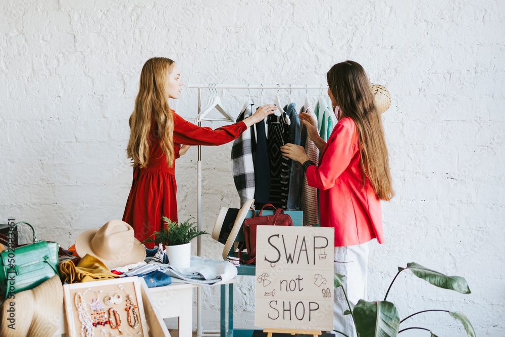 two young woman female caucasian students at swap party try on clothes ...