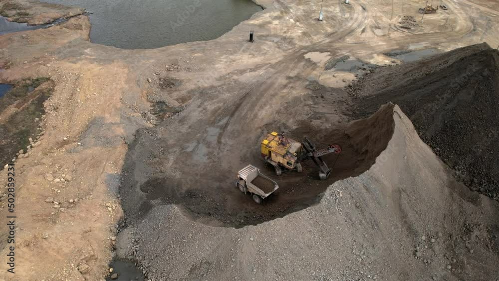 Mining excavator loading dolomite minerals in haul truck. Limestone ...