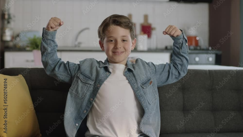 Little boy shows his arm muscles to the camera.Portrait of little boy ...