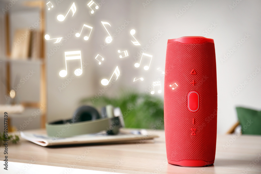 Music playing through wireless portable speaker on table in room 스톡 사진 ...