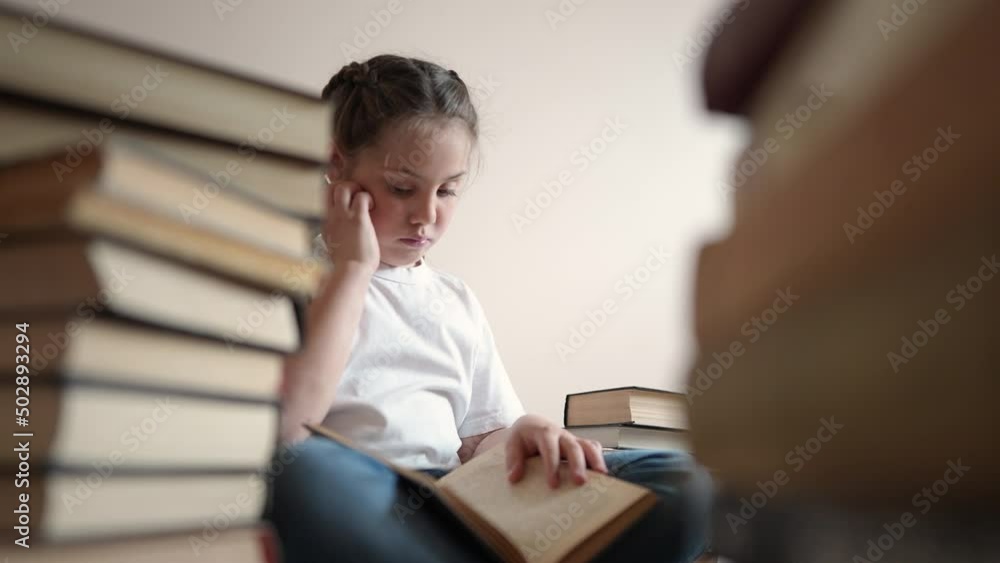 little girl in the library reading a book. education school kid ...