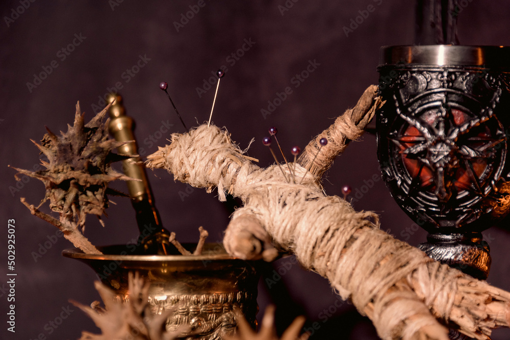 Voodoo doll, black candles, pentagram and old books on witch table ...