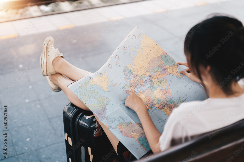 Back side of traveler girl searching right direction on map, traveling ...