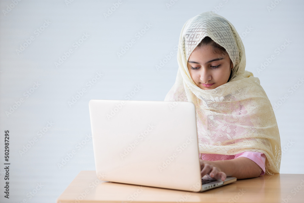 muslim girl in hijab using a laptop computer and online learning or ...
