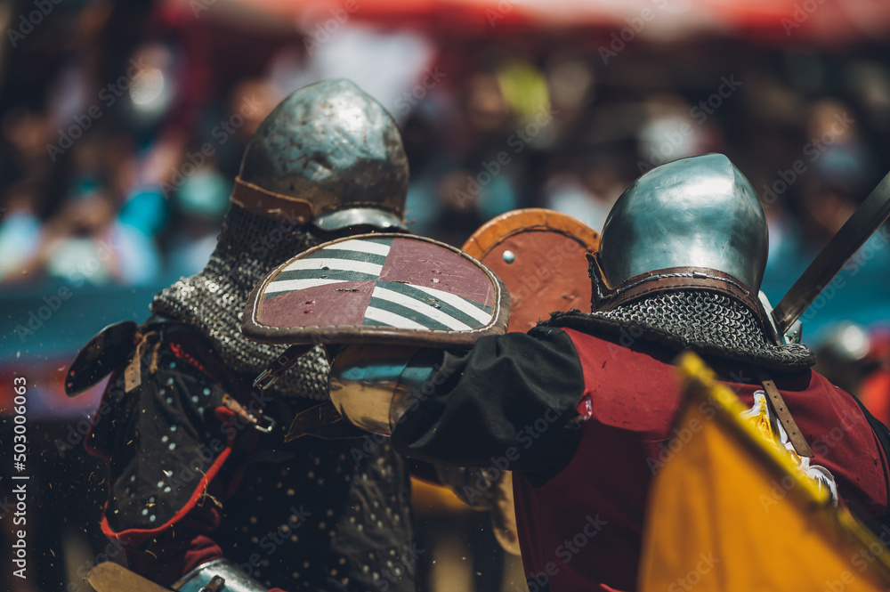 Pitch battle of medieval knights, using metal armor, axes, swords and ...