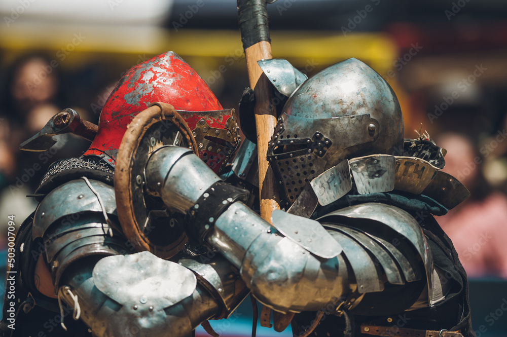 Pitch battle of medieval knights, using metal armor, axes, swords and ...