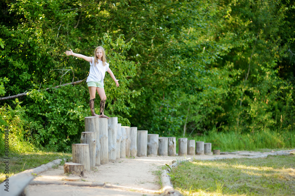 Young girl on tactile path in barefoot park created to feel the ground ...