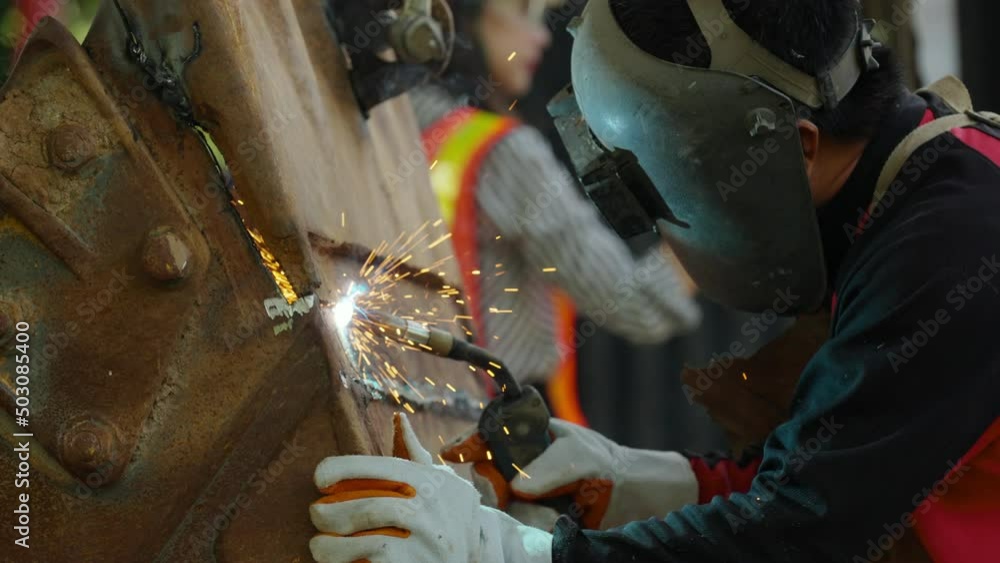 4K Man welder wearing safety equipment working on welding machine in ...