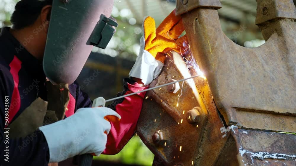 4K Man welder wearing safety equipment working on welding machine in ...