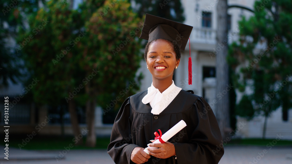 Beautiful black woman graduate posing with her diploma in front of the ...