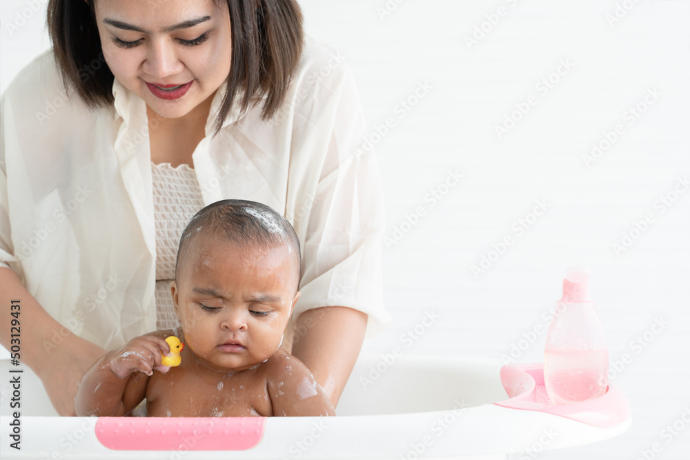Cute African newborn baby bathing in bathtub with soap bubbles on head ...