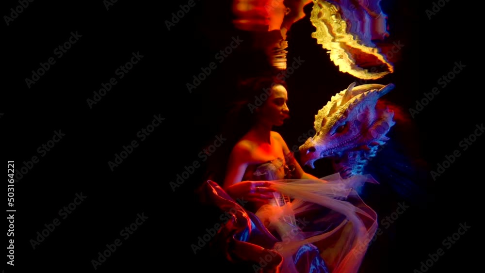 dangerous mysterious dragon and fragile lady are floating in dark depth ...