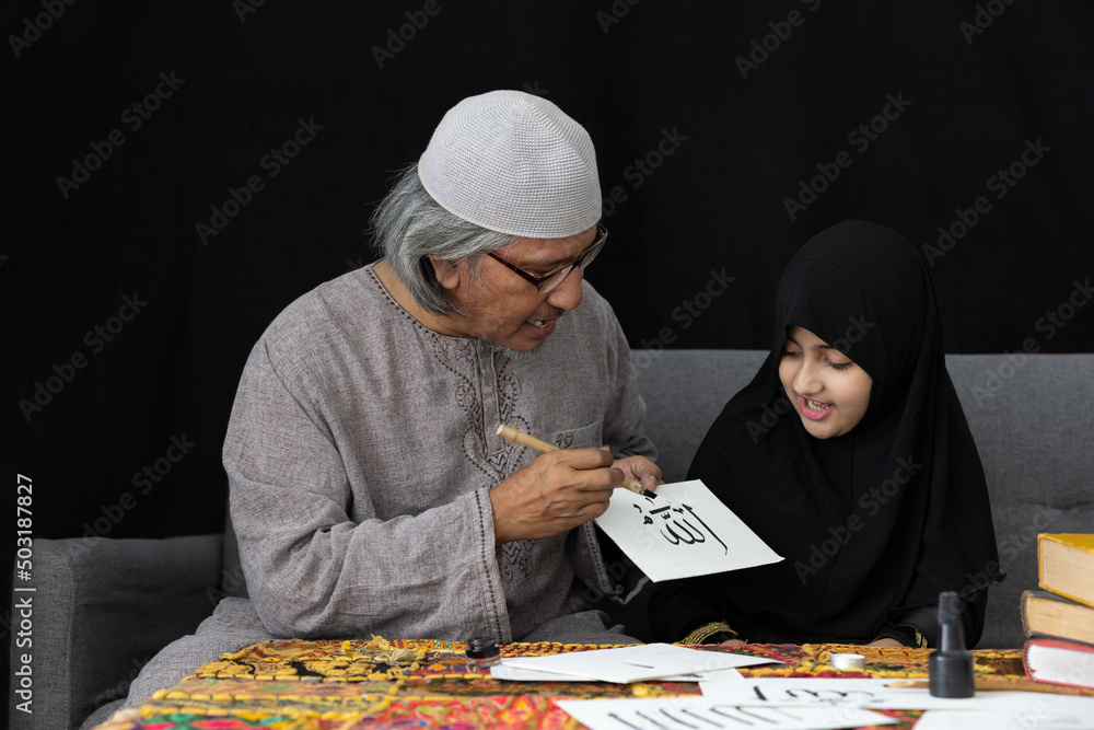 muslim father teaching his daughter about practicing writing Arabic ...