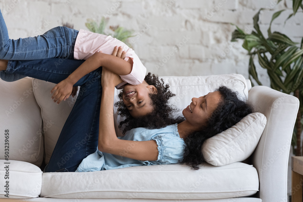 Cheerful Black mom and preschool daughter kid playing active games on ...