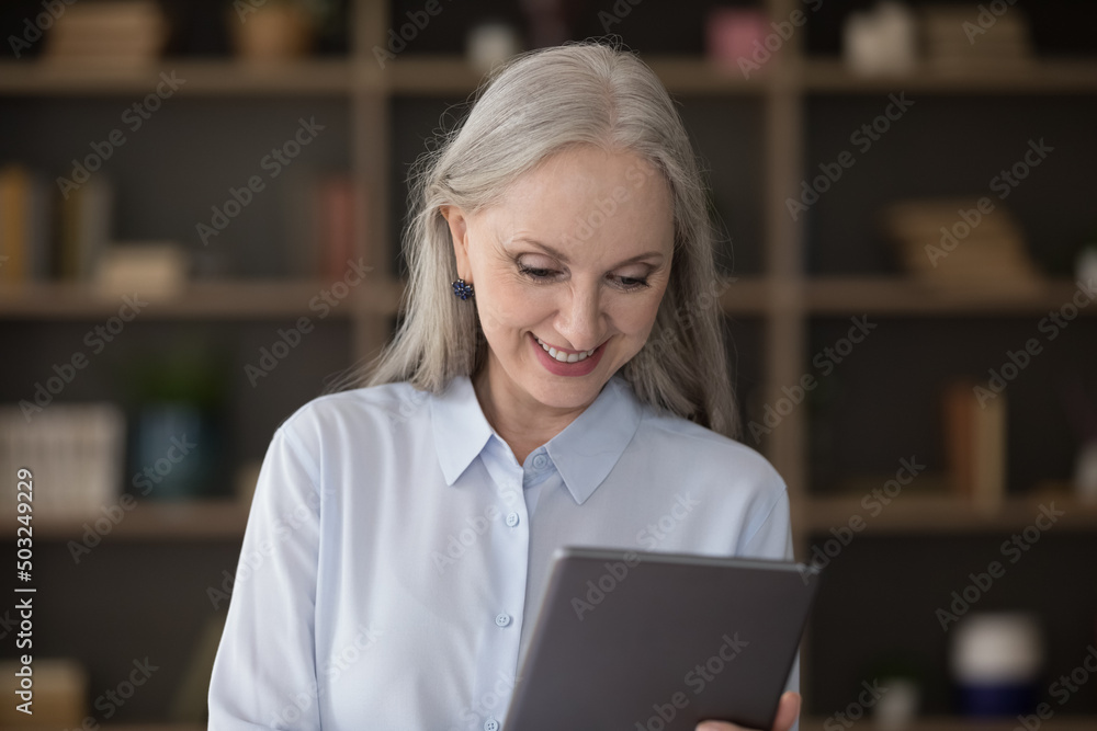 Happy satisfied mature lady using online app on tablet, virtual bank ...