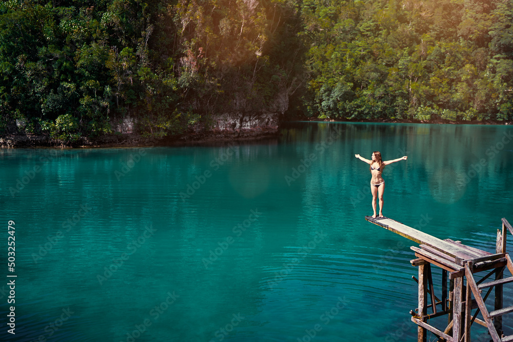 Vacation and activity. Young woman in swimsuit enjoying blue tropical ...