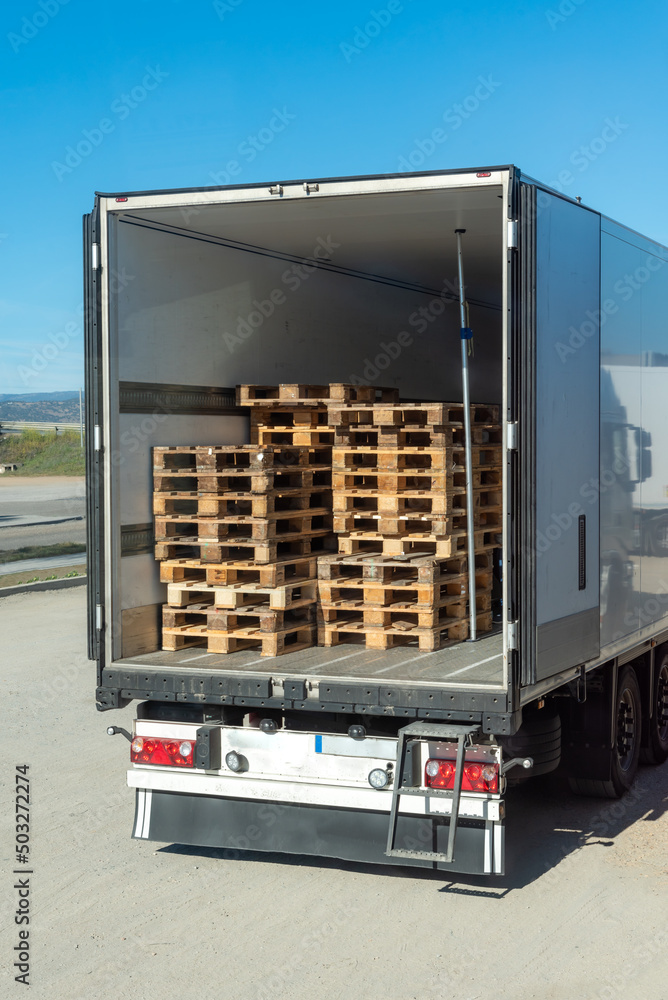 Refrigerated semi-trailer with open doors and empty Euro pallets inside ...