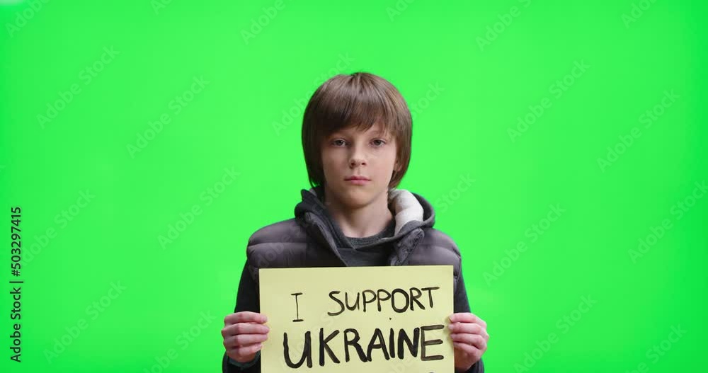 Portrait of frustrated little boy with sign supporting Ukraine protests ...
