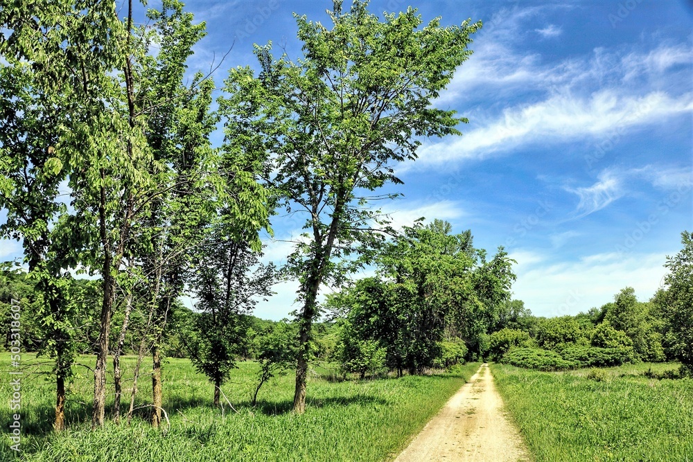 Beneath the blue sky and white clouds of a beautiful summer day in Wisconsin, a dirt bike and ...