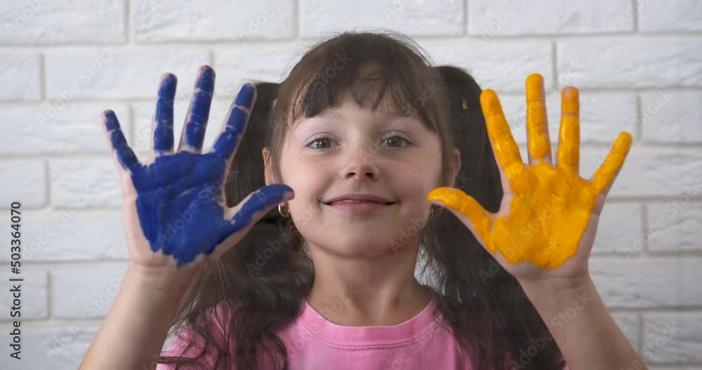 Making handprints on window. A cute nice child makes handprints with ...