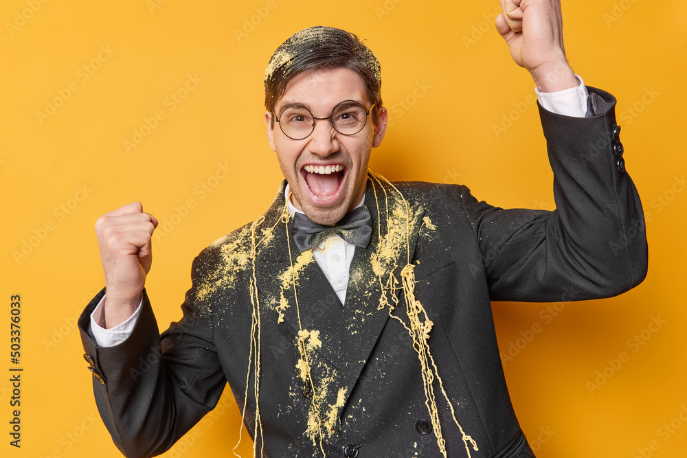 Emotional positive adult man dressed in formal clothes makes winner ...