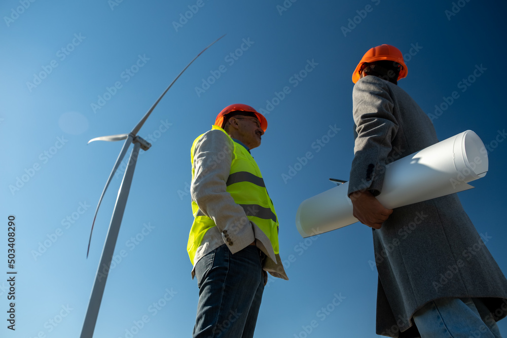 Wind turbine rotates producing electric energy. Experienced engineer ...