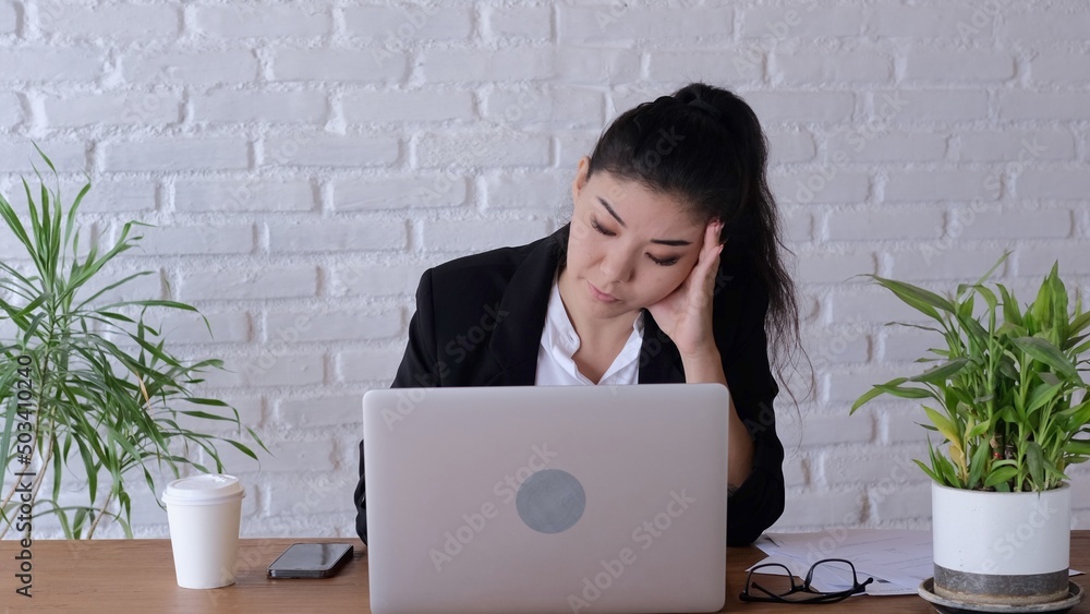 An employee of the office with a tired look during the working day does ...