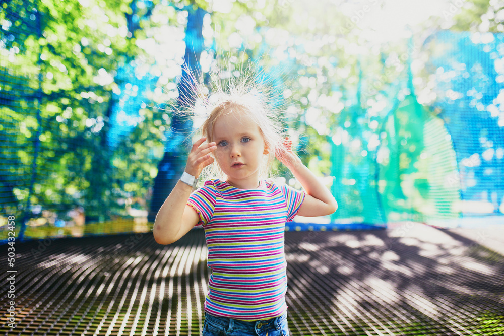 Girl having fun in adventure park. Child with electrified hair on tree ...