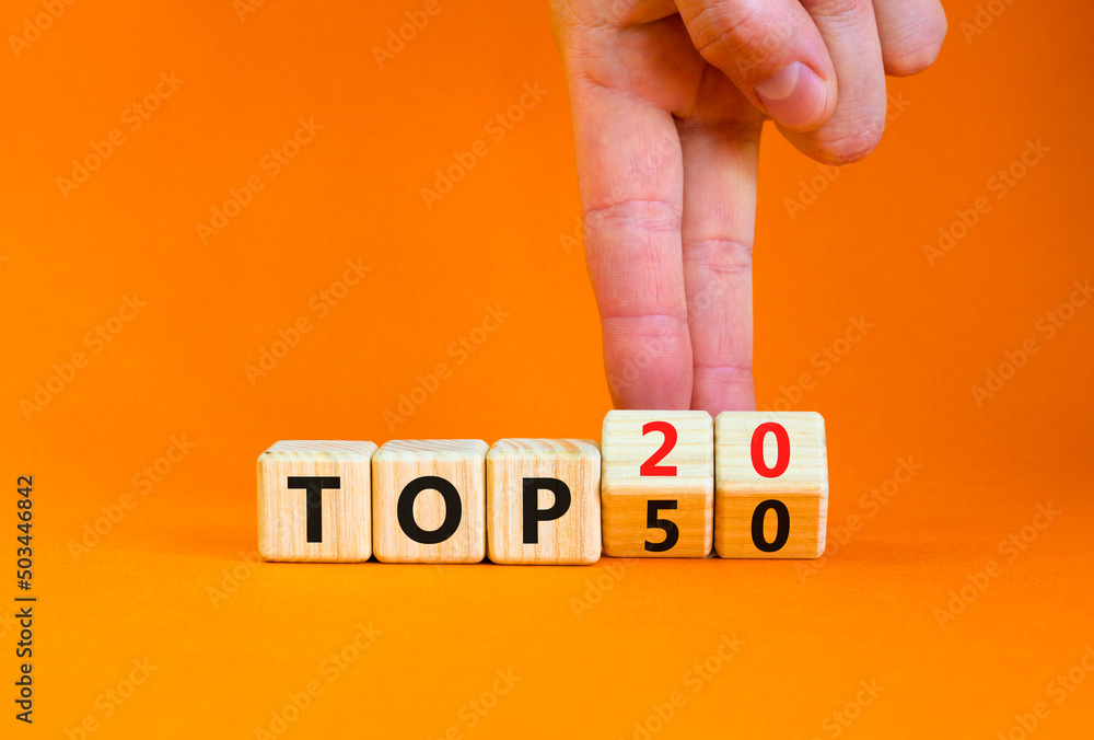 From Top 50 to 20 symbol. Businessman turns wooden cubes and changes ...