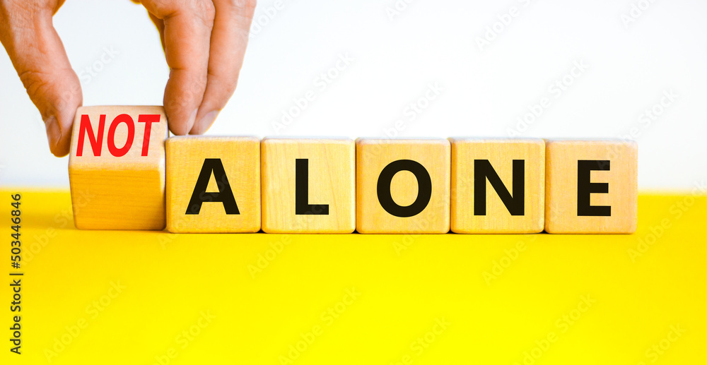 You are not alone symbol. Businessman turns wooden cubes and changes ...