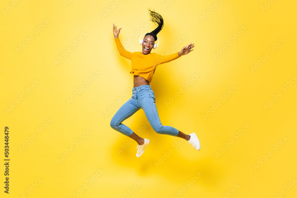 Full body portrait of happy African American woman listening to music ...