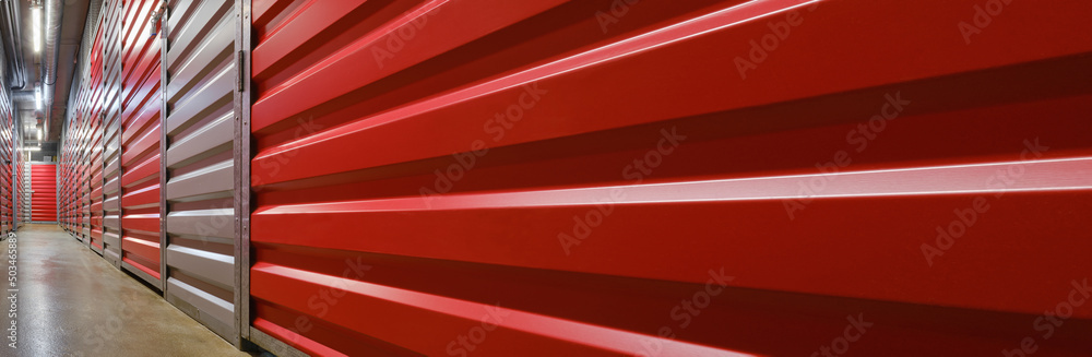 Storage corridor warehouse. Self storage facility, red metal doors with ...