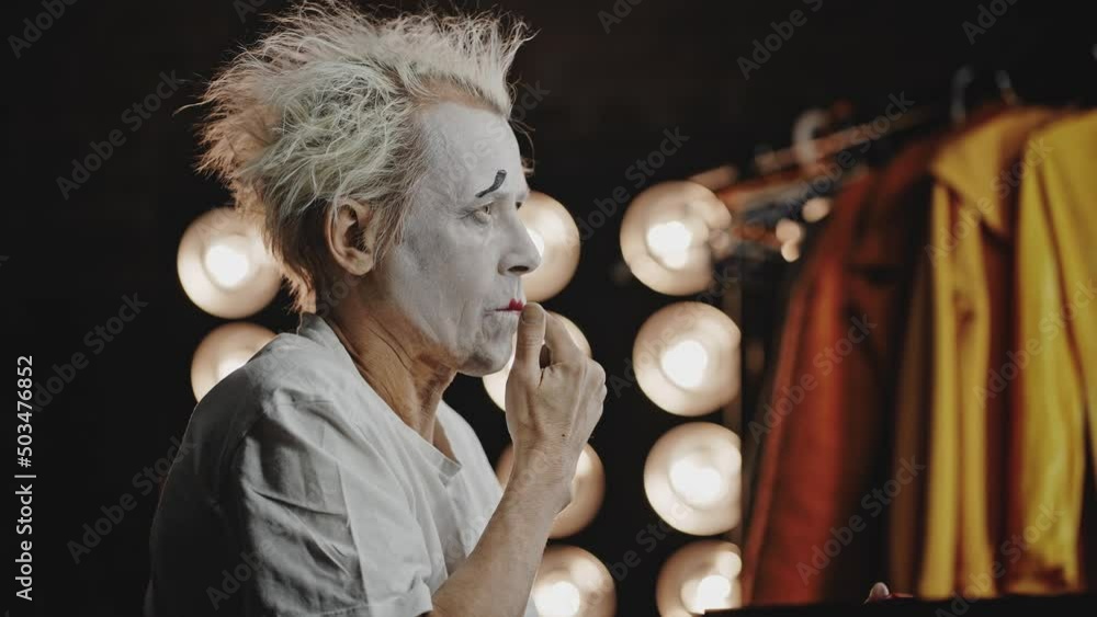 Mime paints lips red doing theatrical makeup in dressing room Stock ...