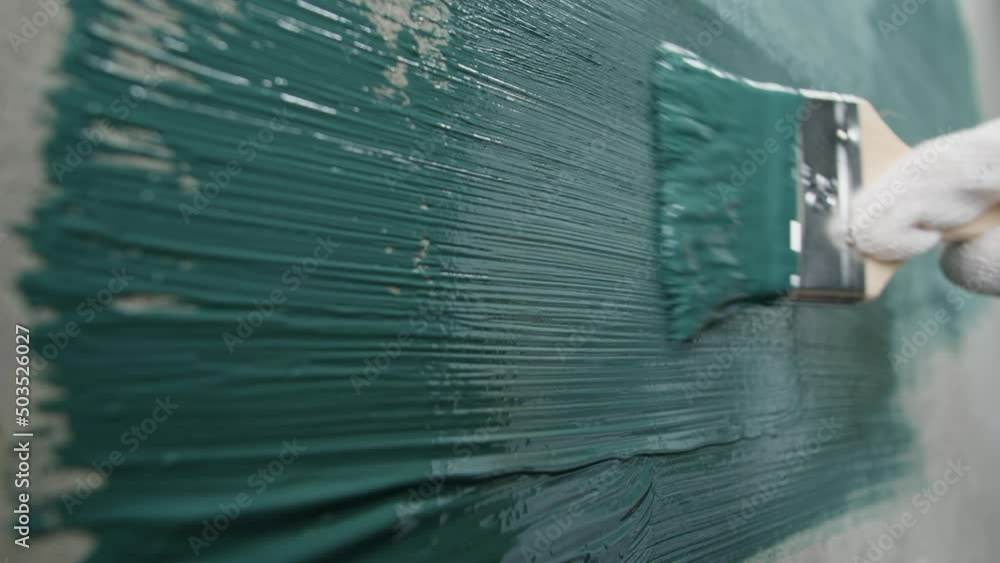 Renovation, painting walls with blue paint using brush close-up ...