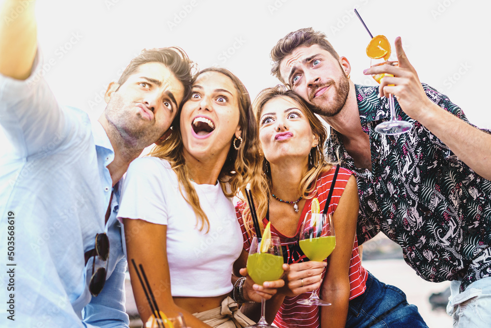 Happy drunk friends taking a selfie making faces holding alcoholic ...