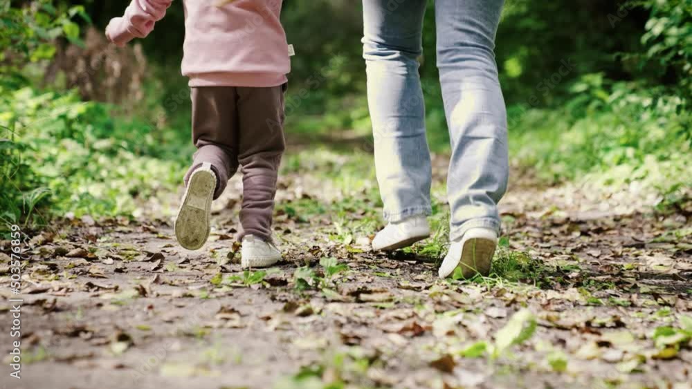Vidéo Stock Mom daughter play in park, run along path holding hands ...