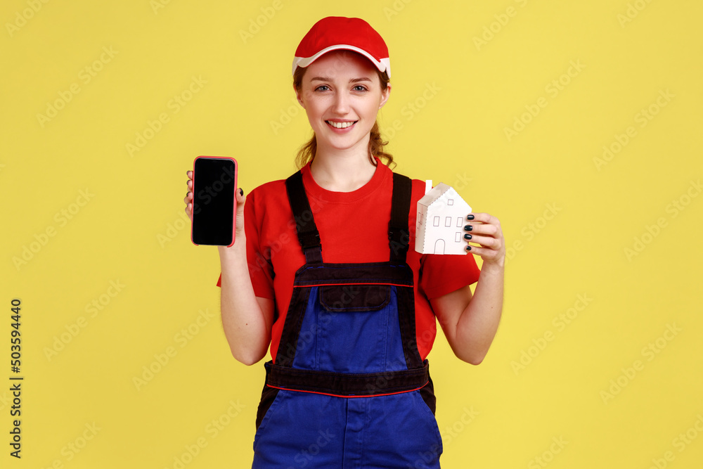Friendly mover woman showing paper house, mobile phone with blank ...