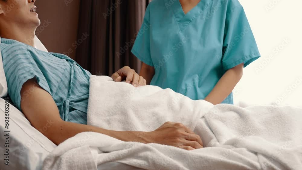 Close up of a nurse touching hand of a man patient on hospital bed ...