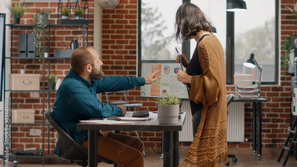 Team of colleagues working together on rate charts design ...