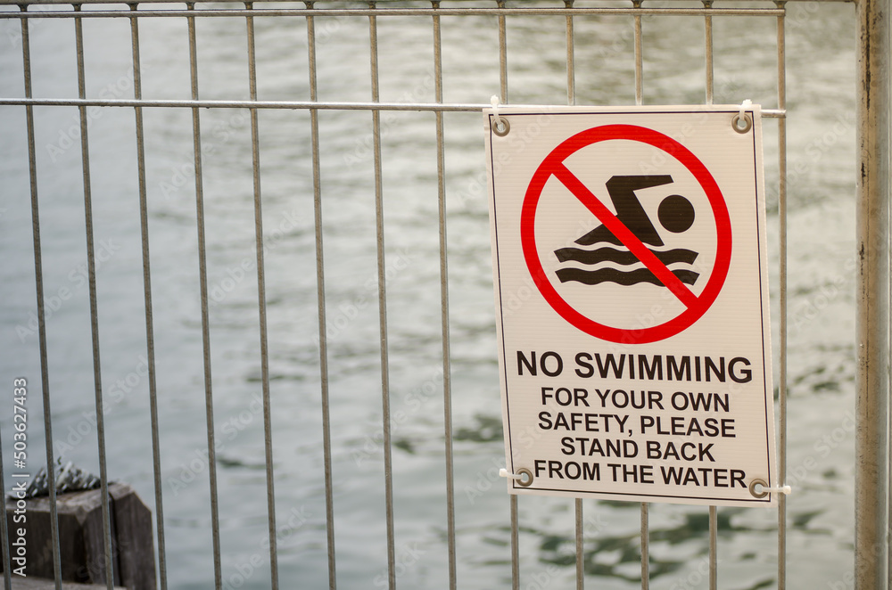 Warning sign for "No swimming for your own safety please stand back ...