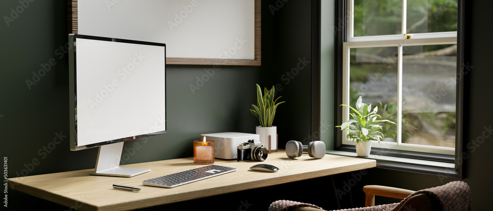 Modern contemporary home workspace with pc computer on table over dark ...