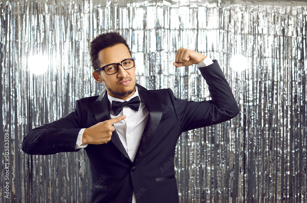 Funny dark-skinned young man in elegant black suit having fun at party ...