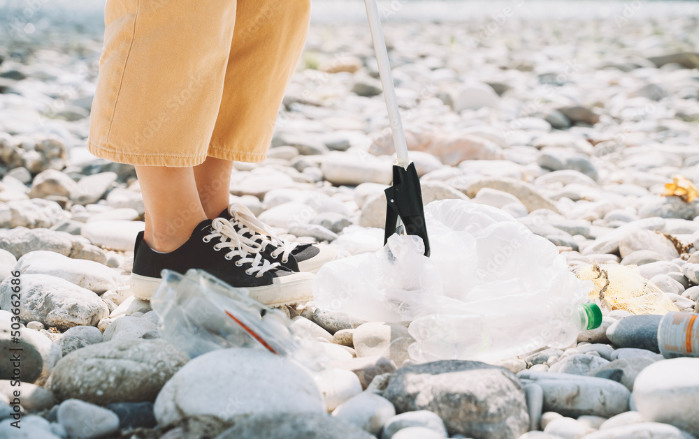 Person help to keep nature clean up and pick up garbage. Young woman ...