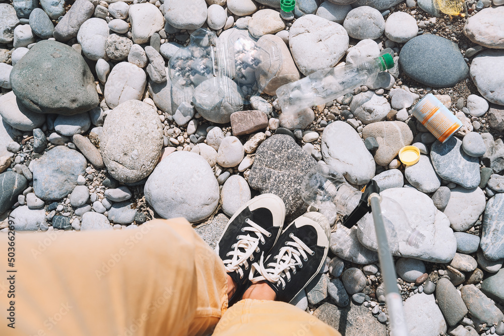 Person help to keep nature clean up and pick up garbage. Young woman ...