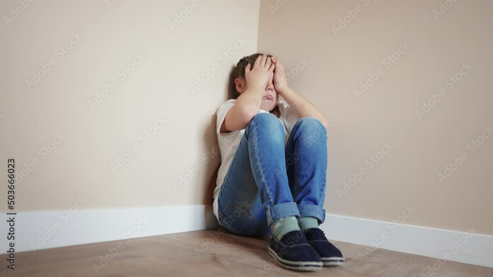 sad girl sitting in the corner crying a covered her face with indoor ...
