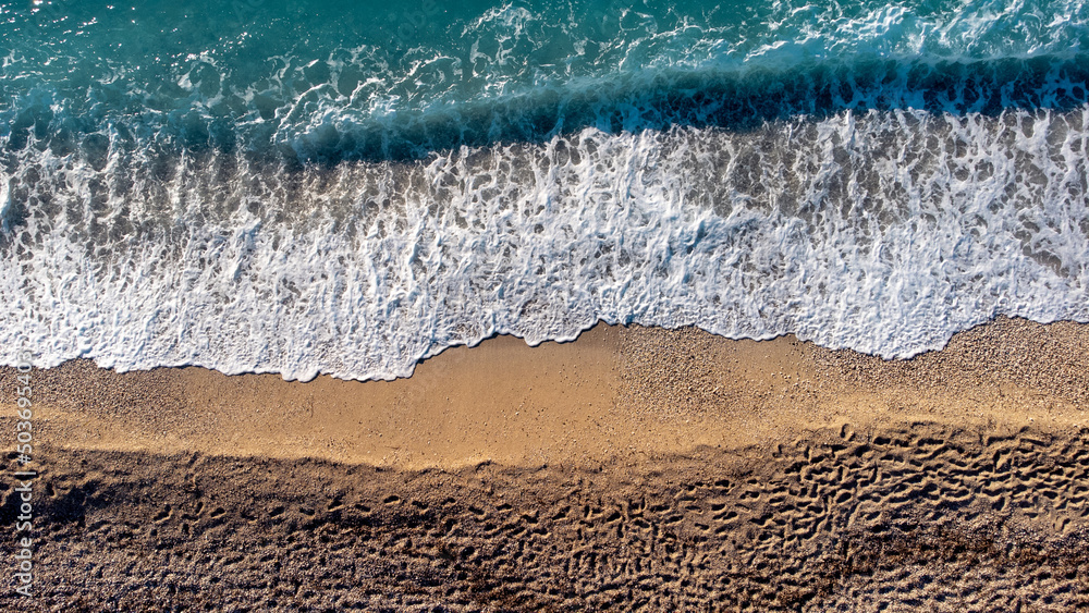 Aerial view of beautiful sandy beach with footprints and soft turquoise ...