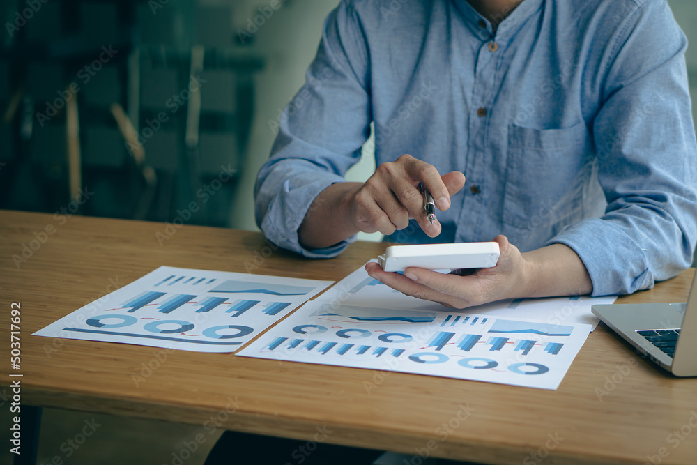 Young Asian businessman hand pressing a calculator to calculate ...