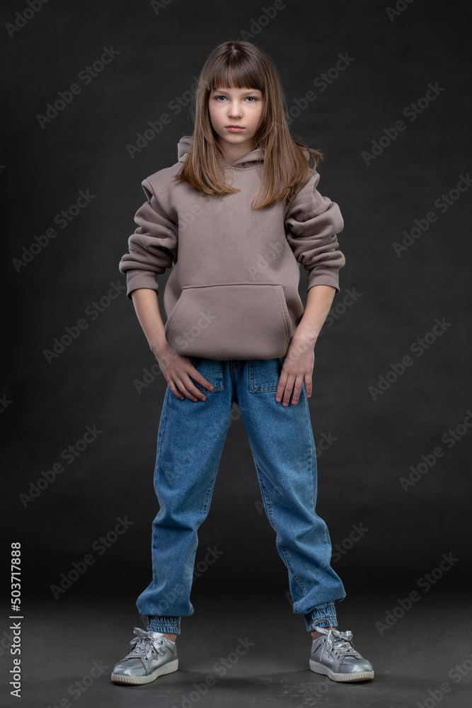 Beautiful fashion model girl of ten years in full growth on a gray ...