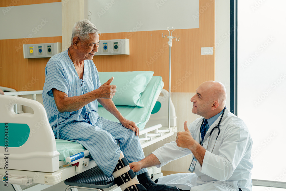 Hospitalized man sitting in bed while doctor checking his pulse. Doctor ...